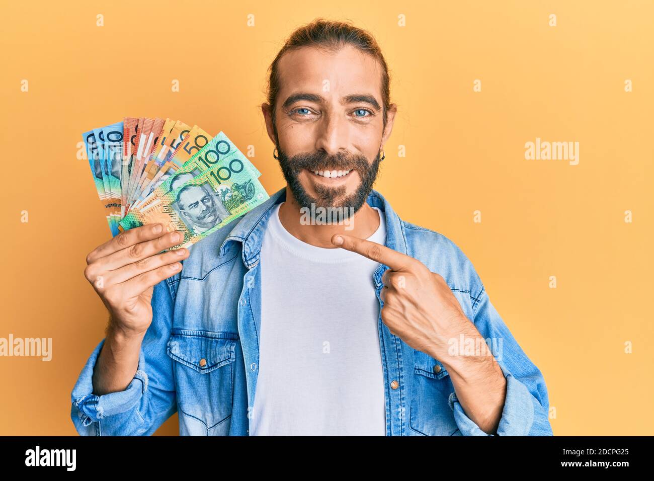 Attractive man with long hair and beard holding australian dollars ...