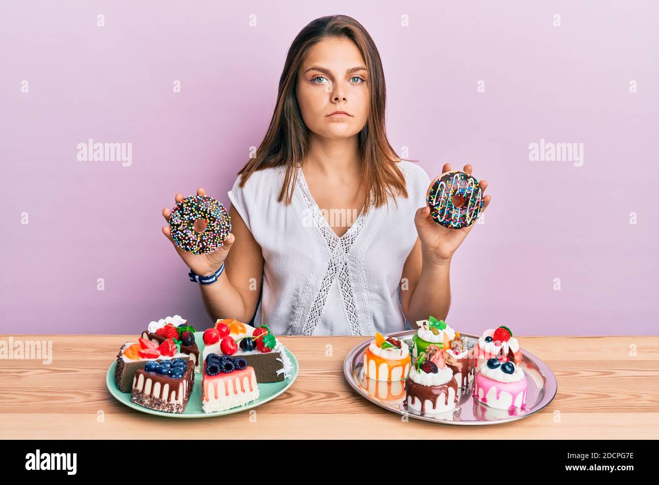Young caucasian woman eating pastries for breakfast relaxed with ...