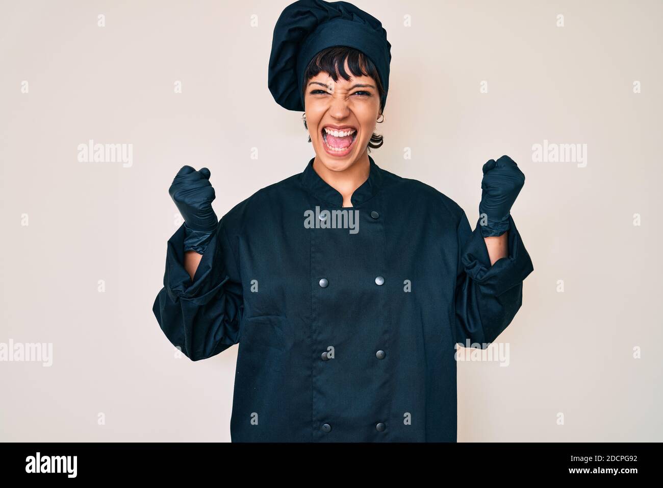 Beautiful brunettte woman wearing professional cook uniform celebrating ...