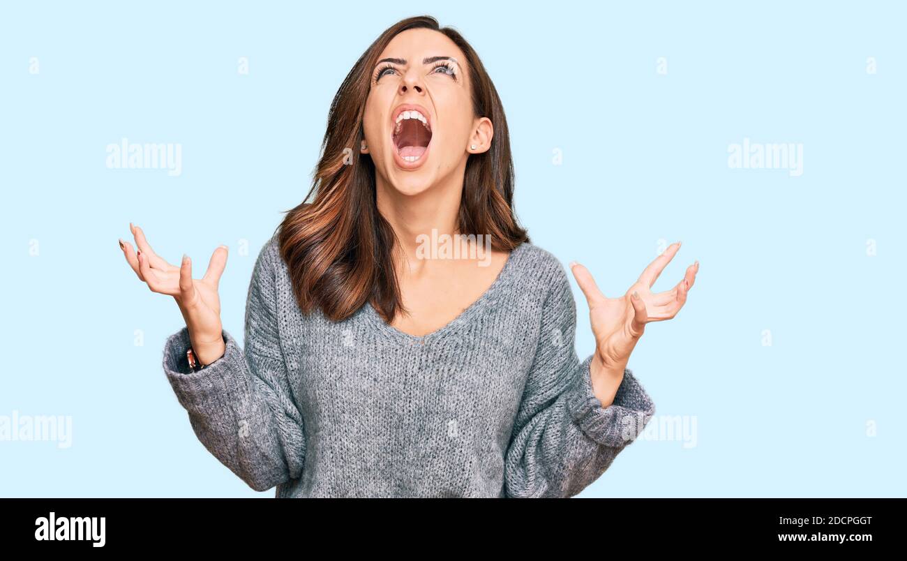 Young brunette woman wearing casual winter sweater crazy and mad ...
