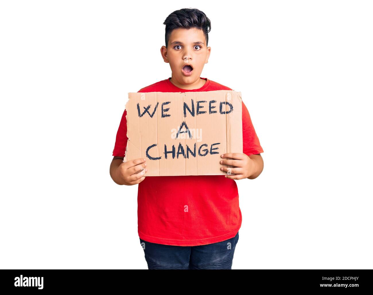 Little boy kid holding we need a change banner scared and amazed with ...