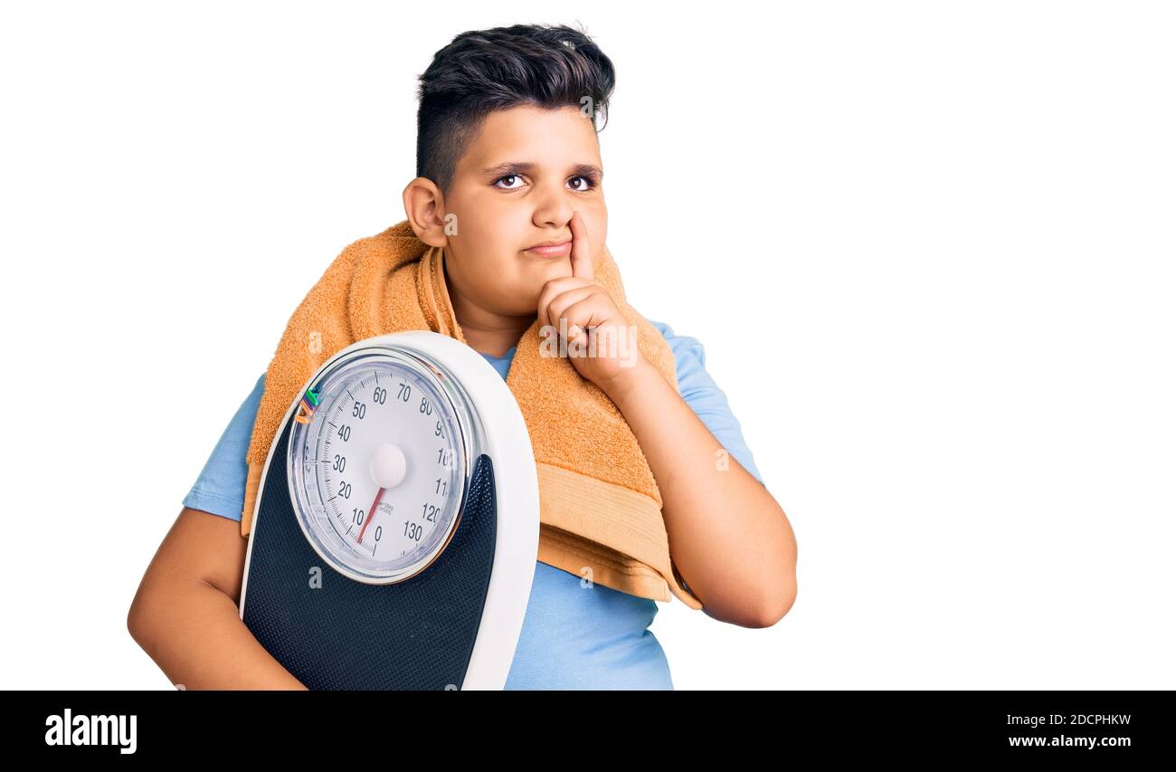 Little boy kid holding weight machine to balance weight loss serious ...