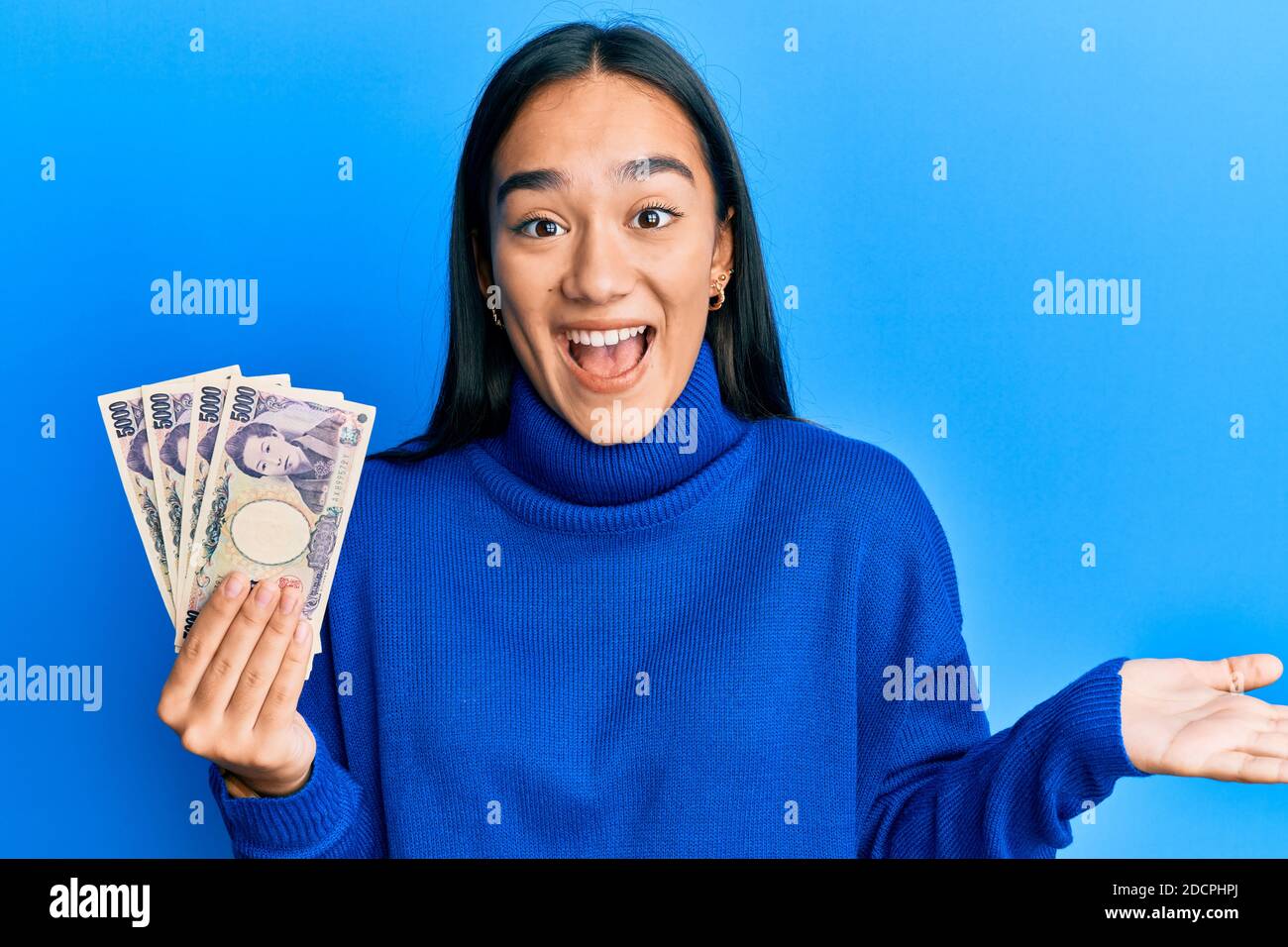 Young asian woman holding 5000 japanese yen banknotes celebrating ...
