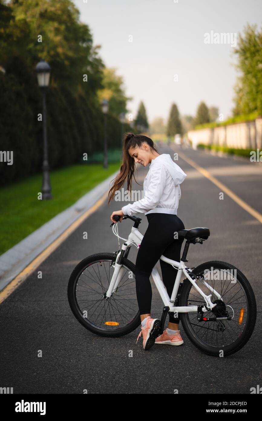 Beautiful girl posing at white bicycle. Walk in nature Stock Photo - Alamy