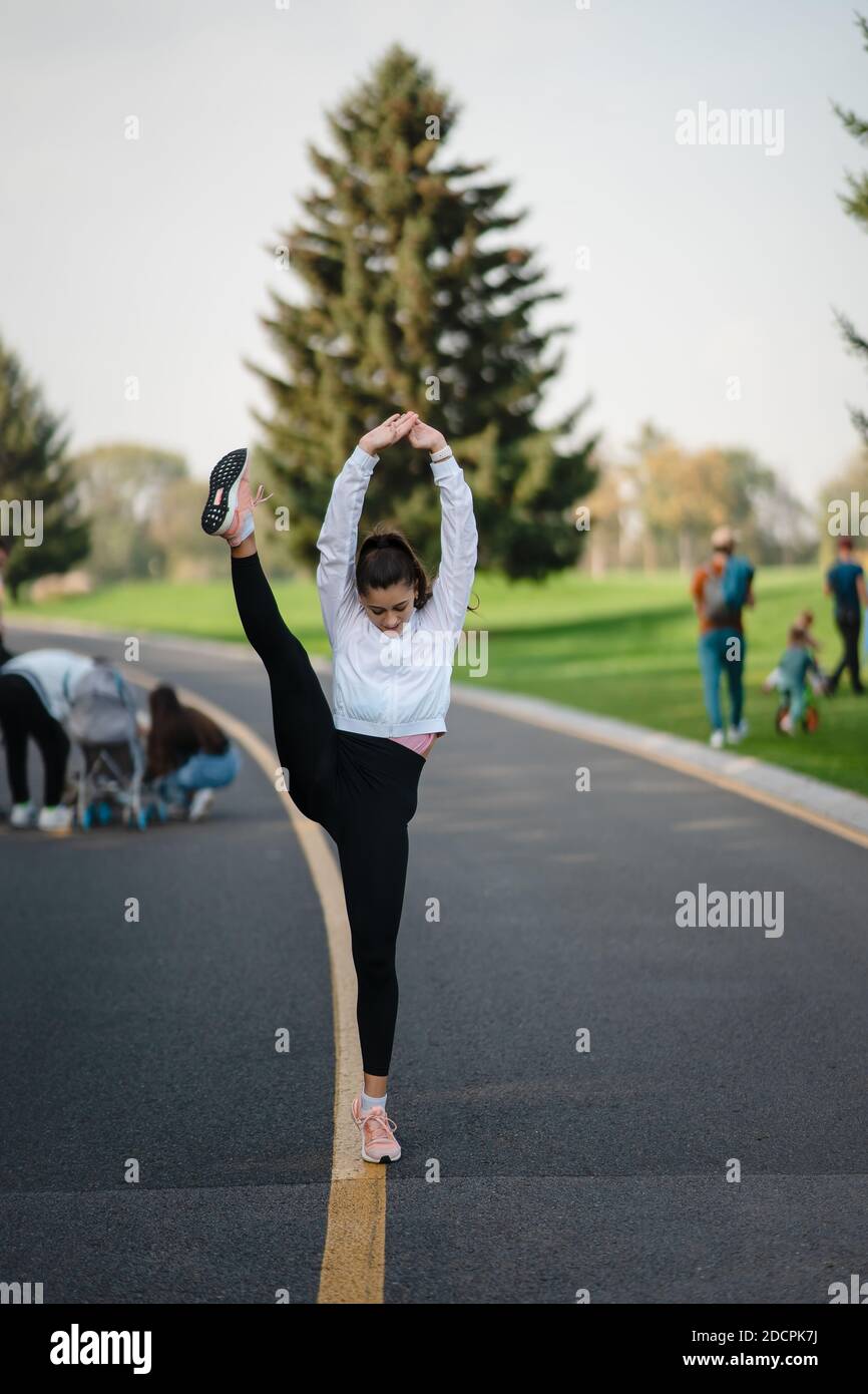 Woman in sport outfit on the road doing doing splits standing Stock ...