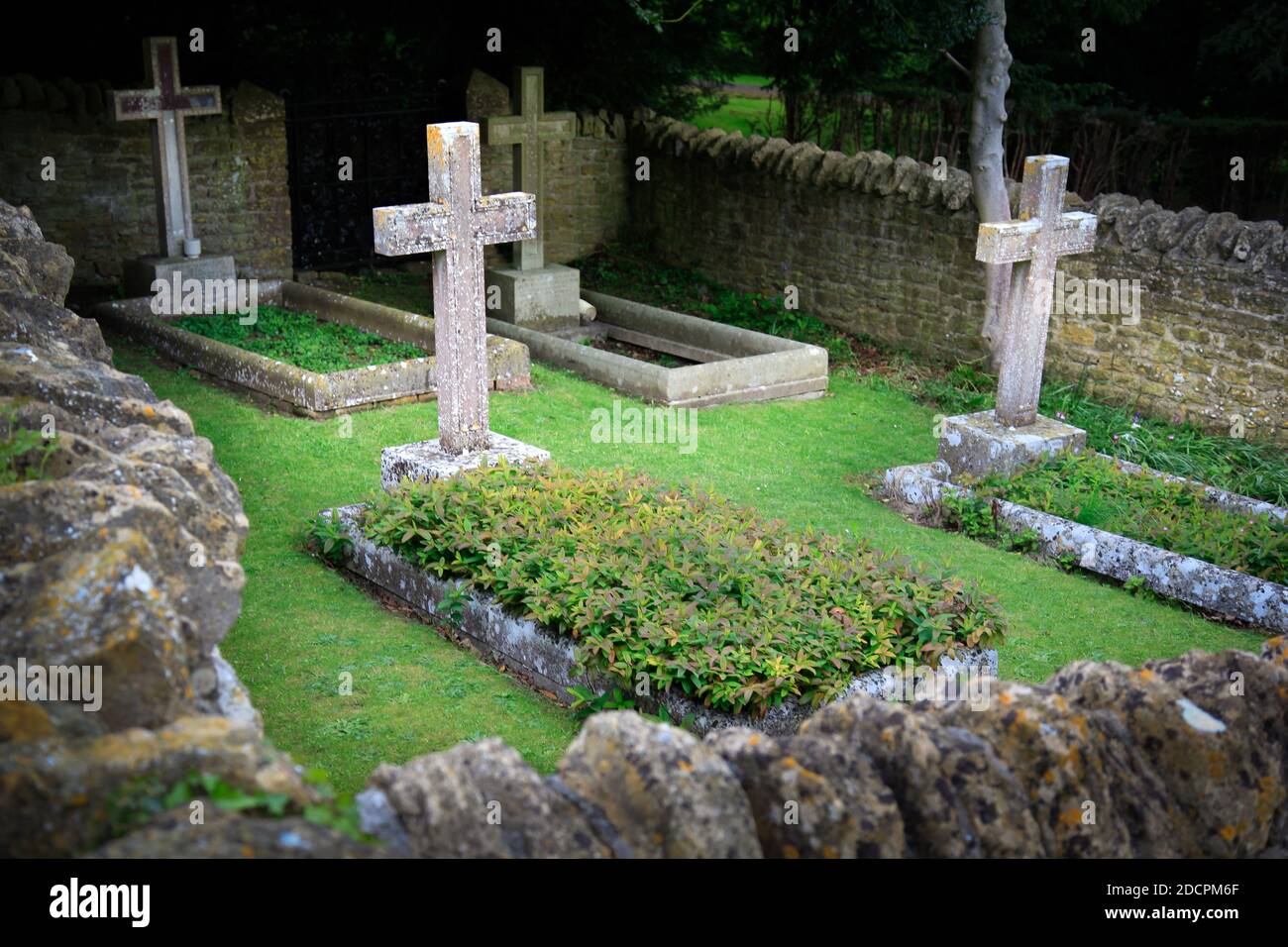 Well kept old sunken graveyard with stone crosses walled with dry stone ...
