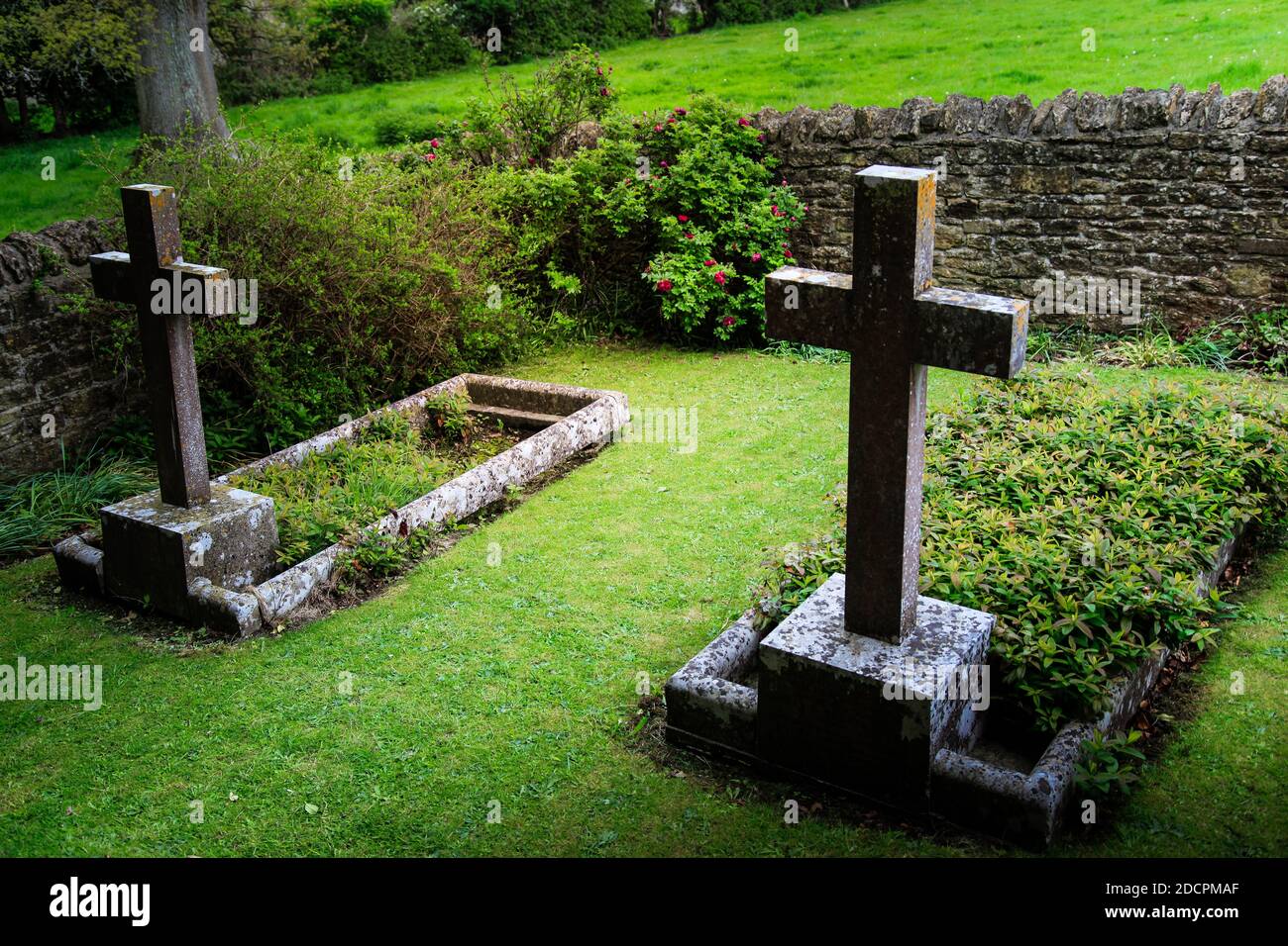 Well kept old sunken graveyard with stone crosses walled with dry stone ...
