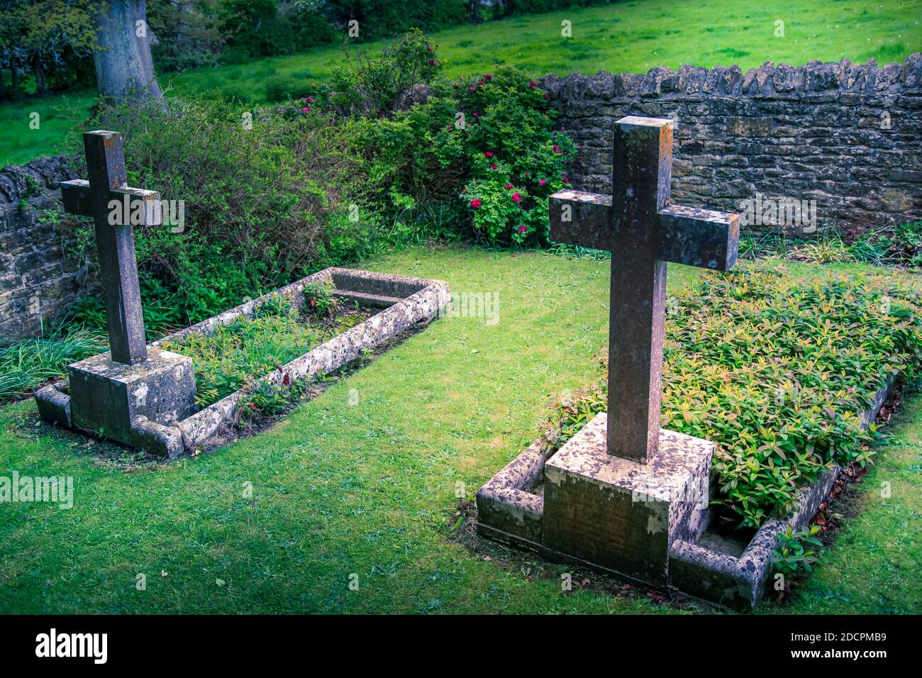 Well kept old sunken graveyard with stone crosses walled with dry stone ...