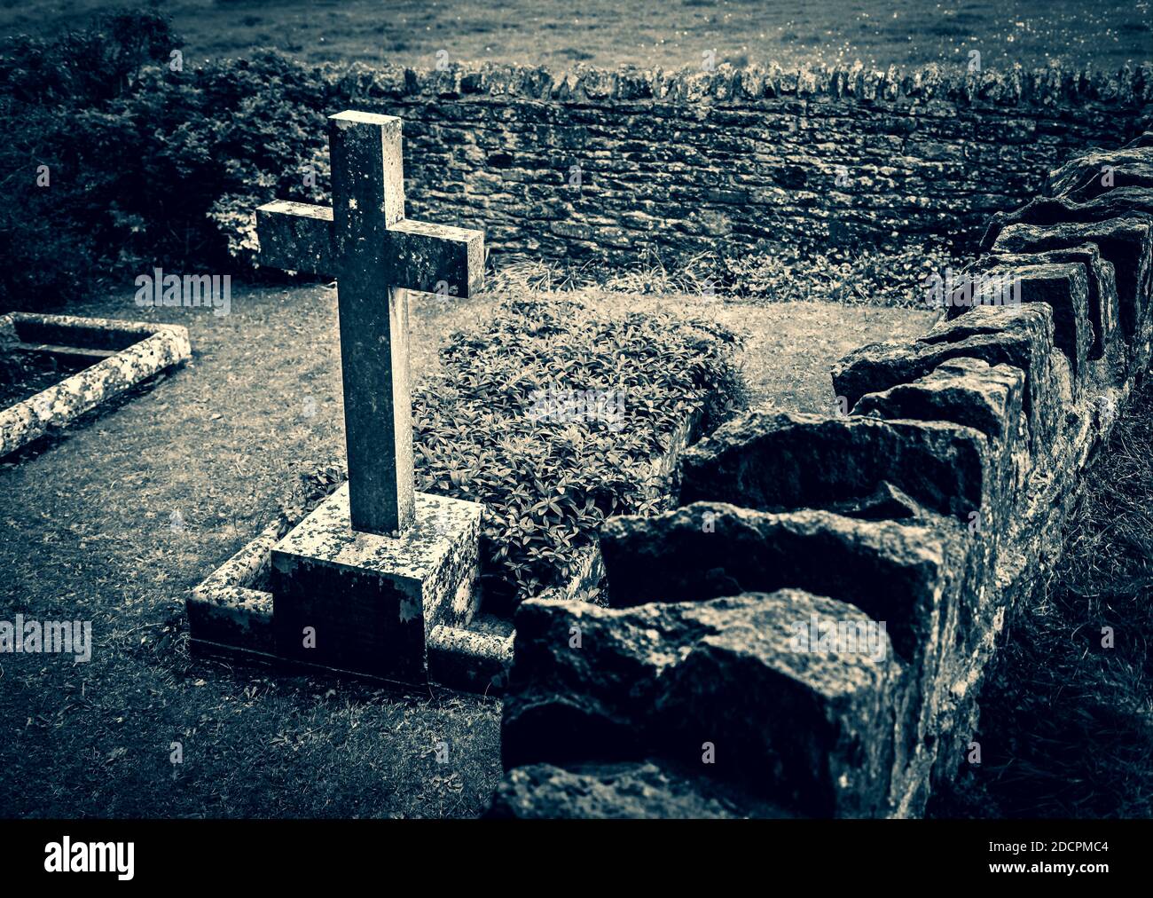Well kept old sunken graveyard with stone crosses walled with dry stone ...