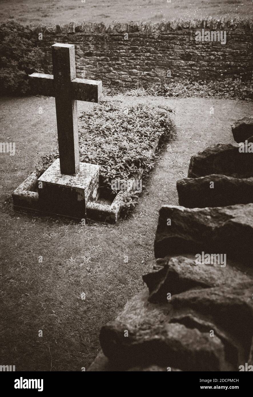 Well kept old sunken graveyard with stone crosses walled with dry stone ...