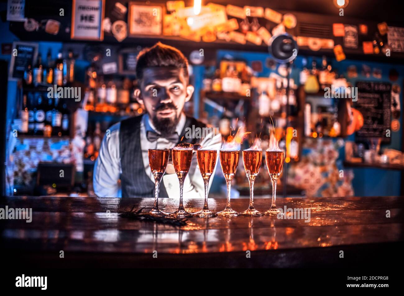 Confident bartender demonstrates his professional skills while standing ...