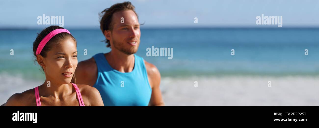 Multiracial couple runners running on beach. Interracial young adults ...