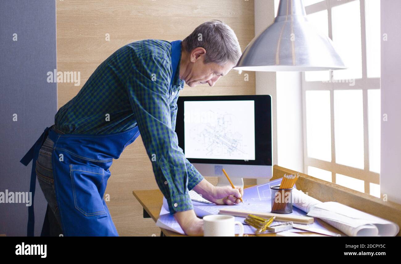 Engineer carpenter working on laptop and sketching project Stock Photo ...