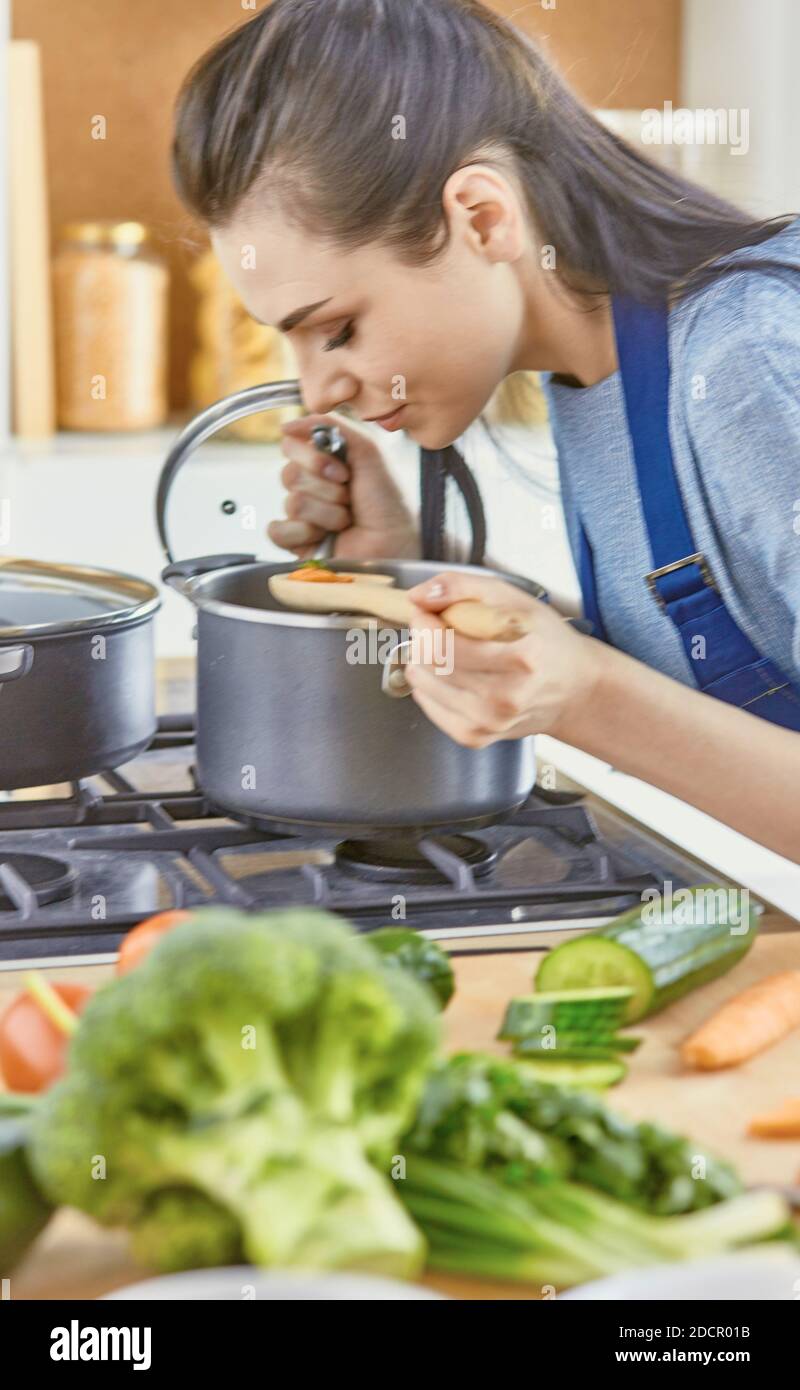 Beautiful woman in the kitchen, waiting with the front of the oven ...