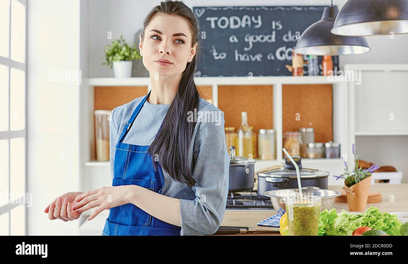 Beautiful woman in the kitchen, waiting with the front of the oven ...