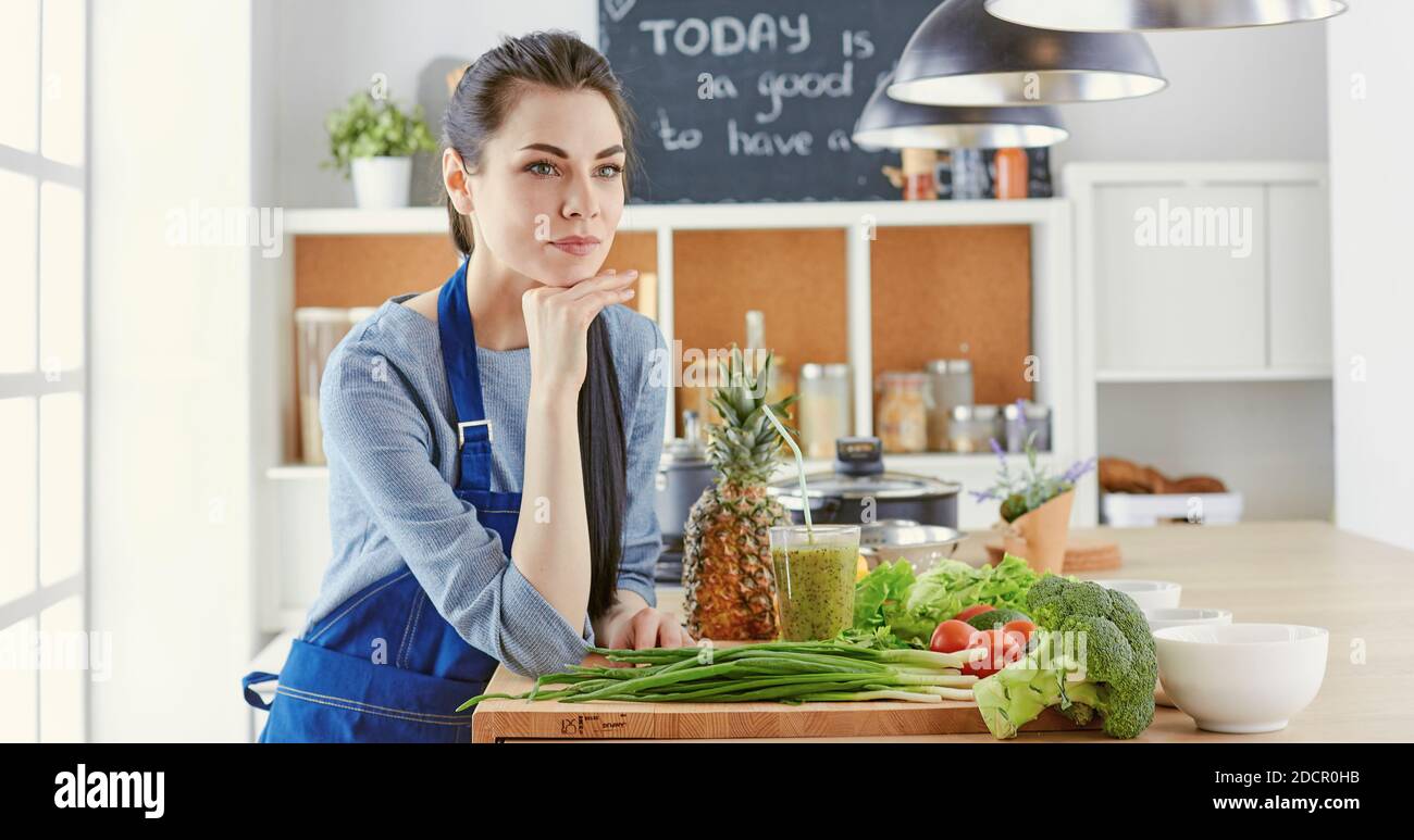 Beautiful woman in the kitchen, waiting with the front of the oven ...