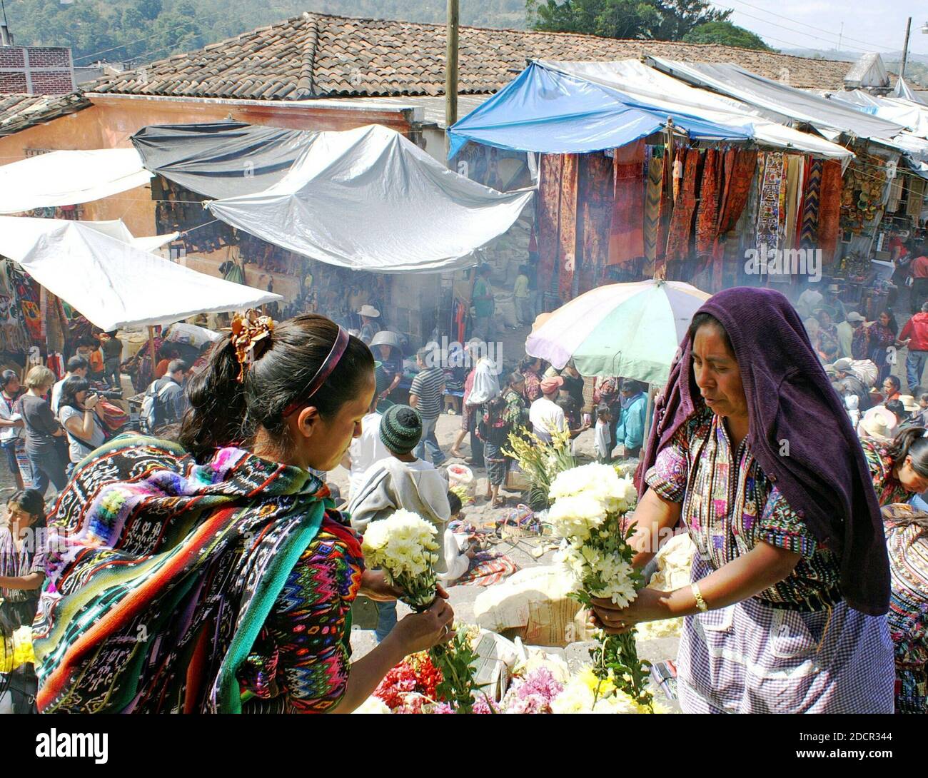 Two women work with flowers in the historic Chichi Market, a colorful ...