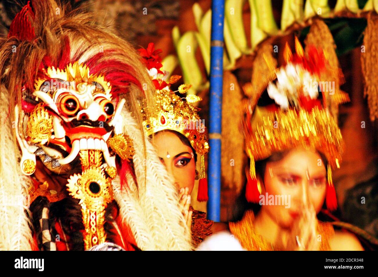 Balinese woman peaks out from behind Leak, a cultural mystical creature ...