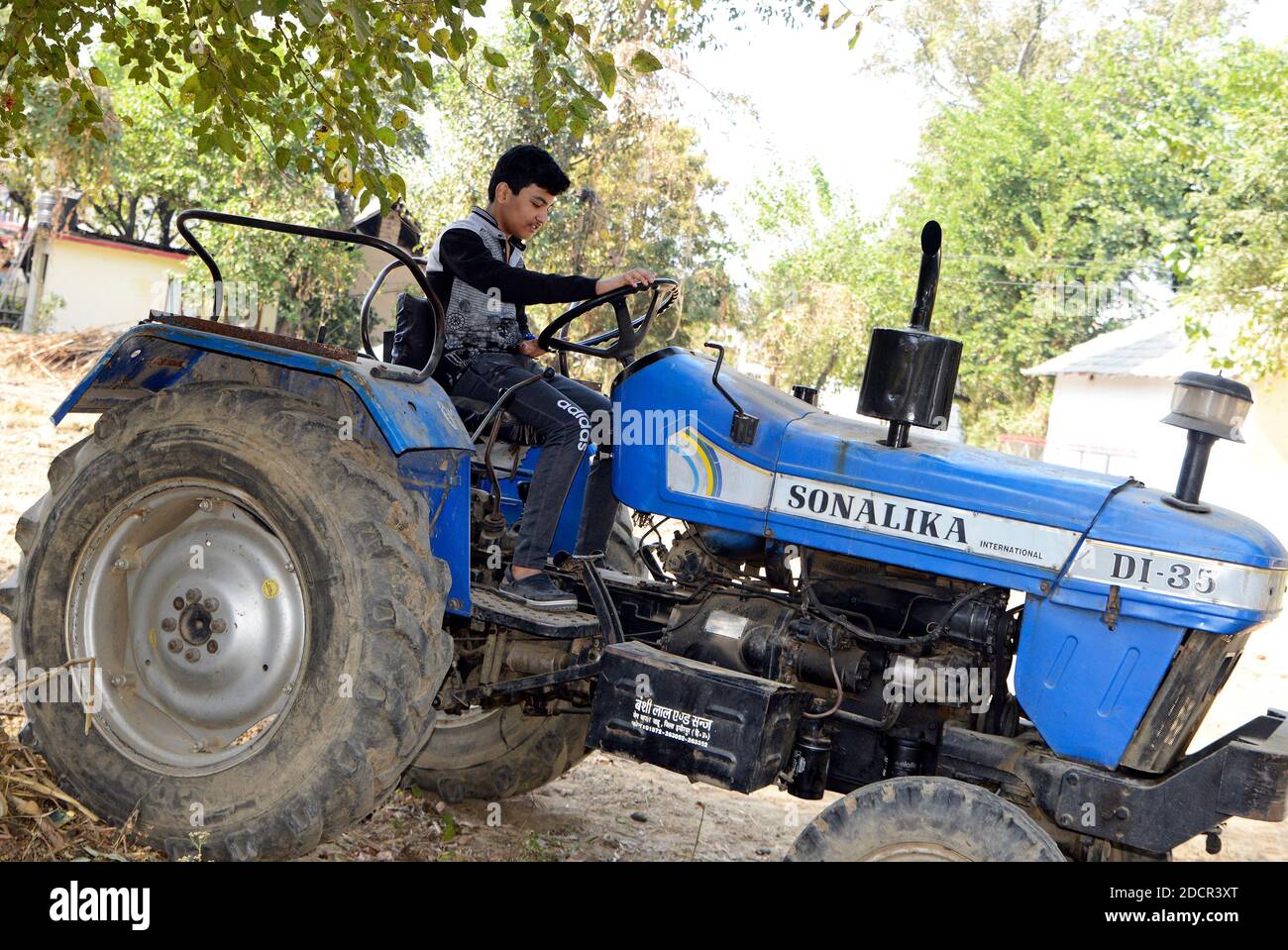 Boy pretending to drive a tractor Stock Photo - Alamy