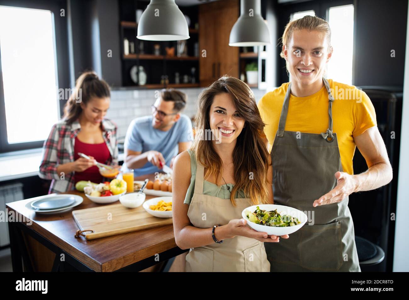 Beautiful happy people, friends is smiling while cooking together in ...