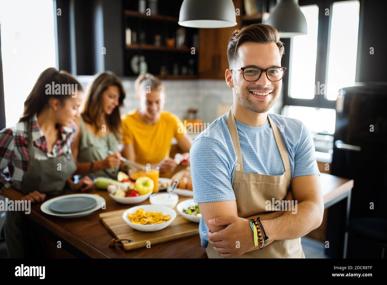 Beautiful happy people, friends is smiling while cooking together in ...