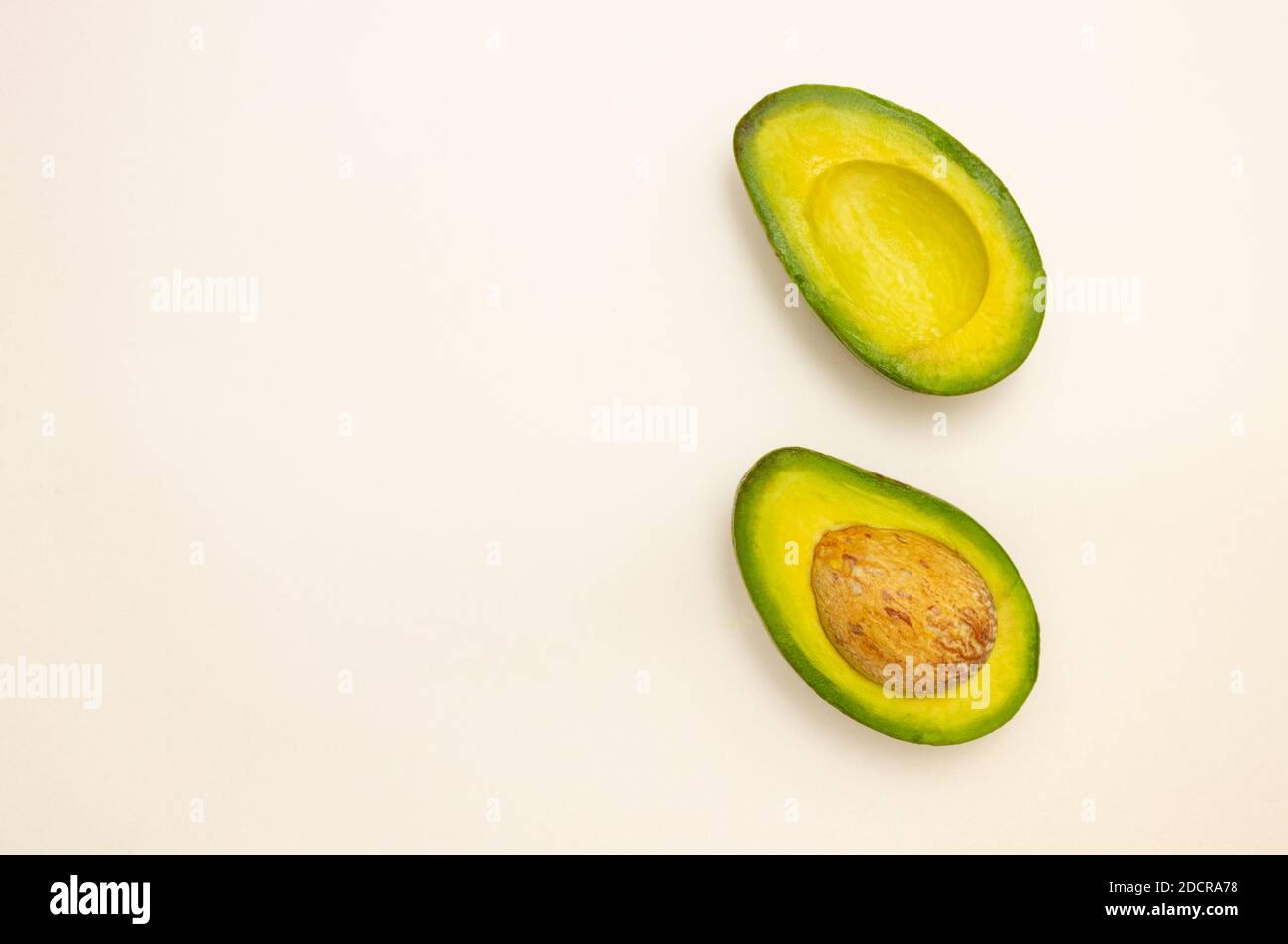 Cut and whole avocado on a light background. Top view, free space for ...