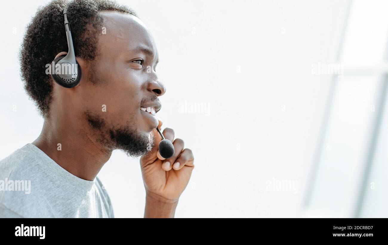 side view. young man with headset talking into microphone Stock Photo ...