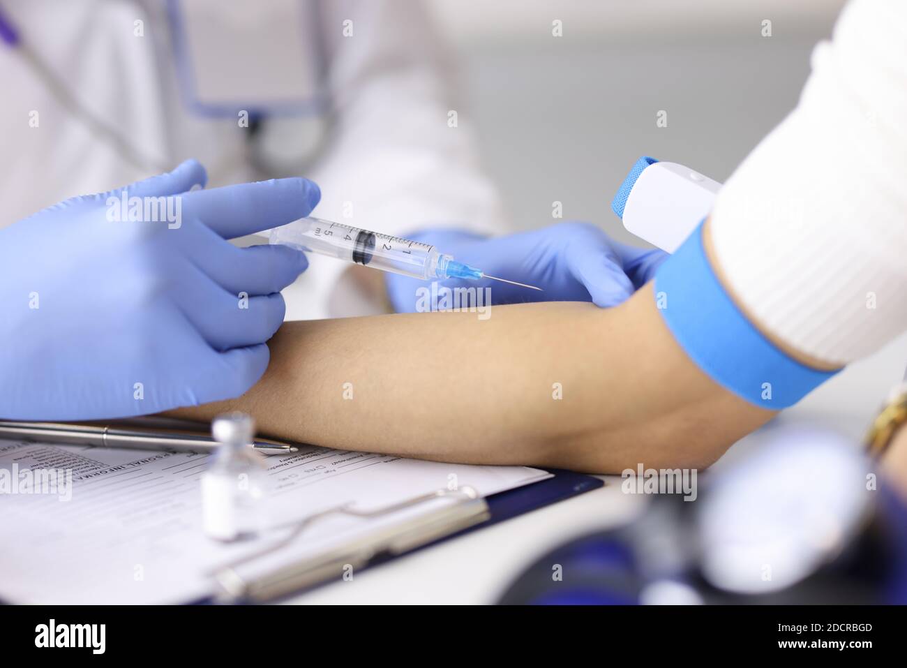 Doctor injecting medication into patients ulnar vein at clinic closeup ...