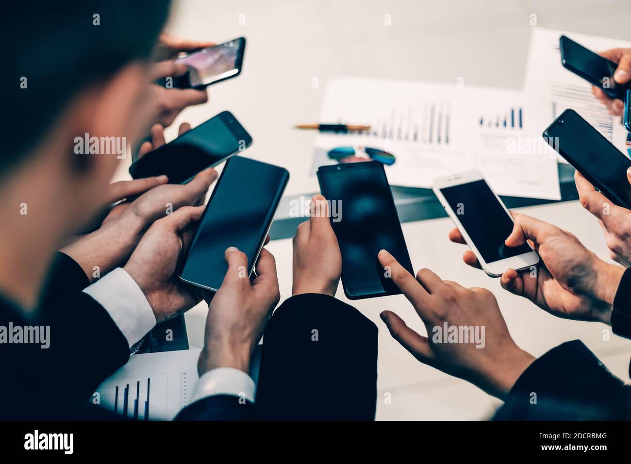 group of employees using their smartphones in the workplace Stock Photo ...