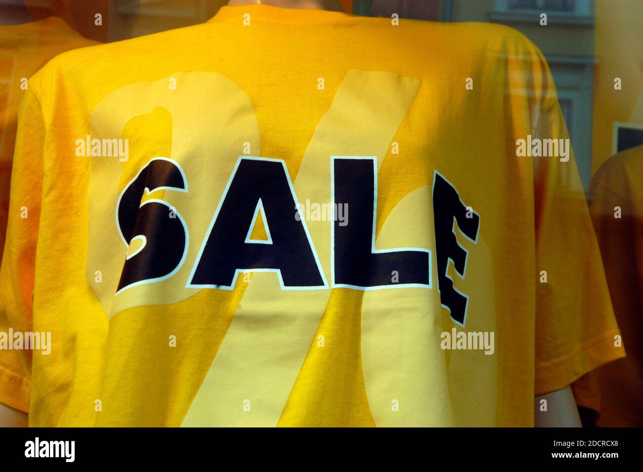 Sale sign in retail on yellow shirt, black letters and percent sign ...