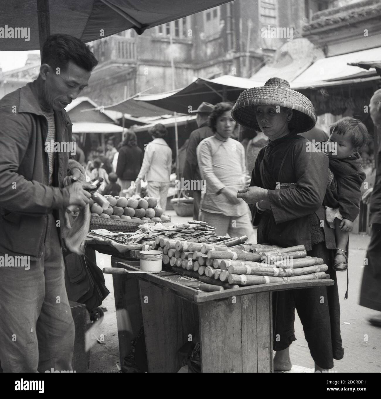 1950s, historical, street trader scraping the skin of his produce ...