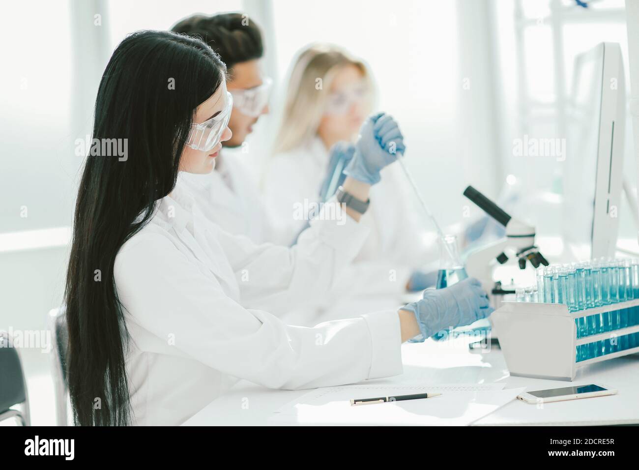 close up. woman scientist looking at the tube with liquid Stock Photo ...