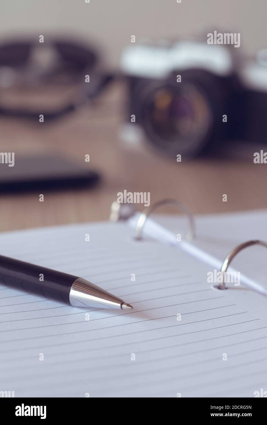 A Vertical Selective Focus Shot Of A Pen On The Blank Notebook Paper