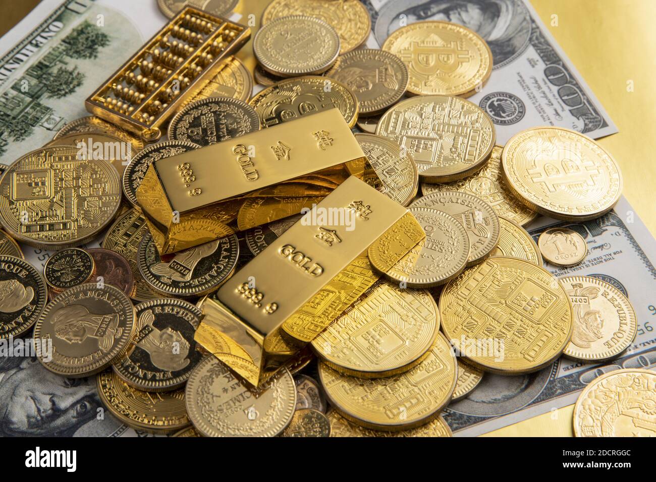 Dollar banknotes, golden coins, and gold bars scattered on a table ...