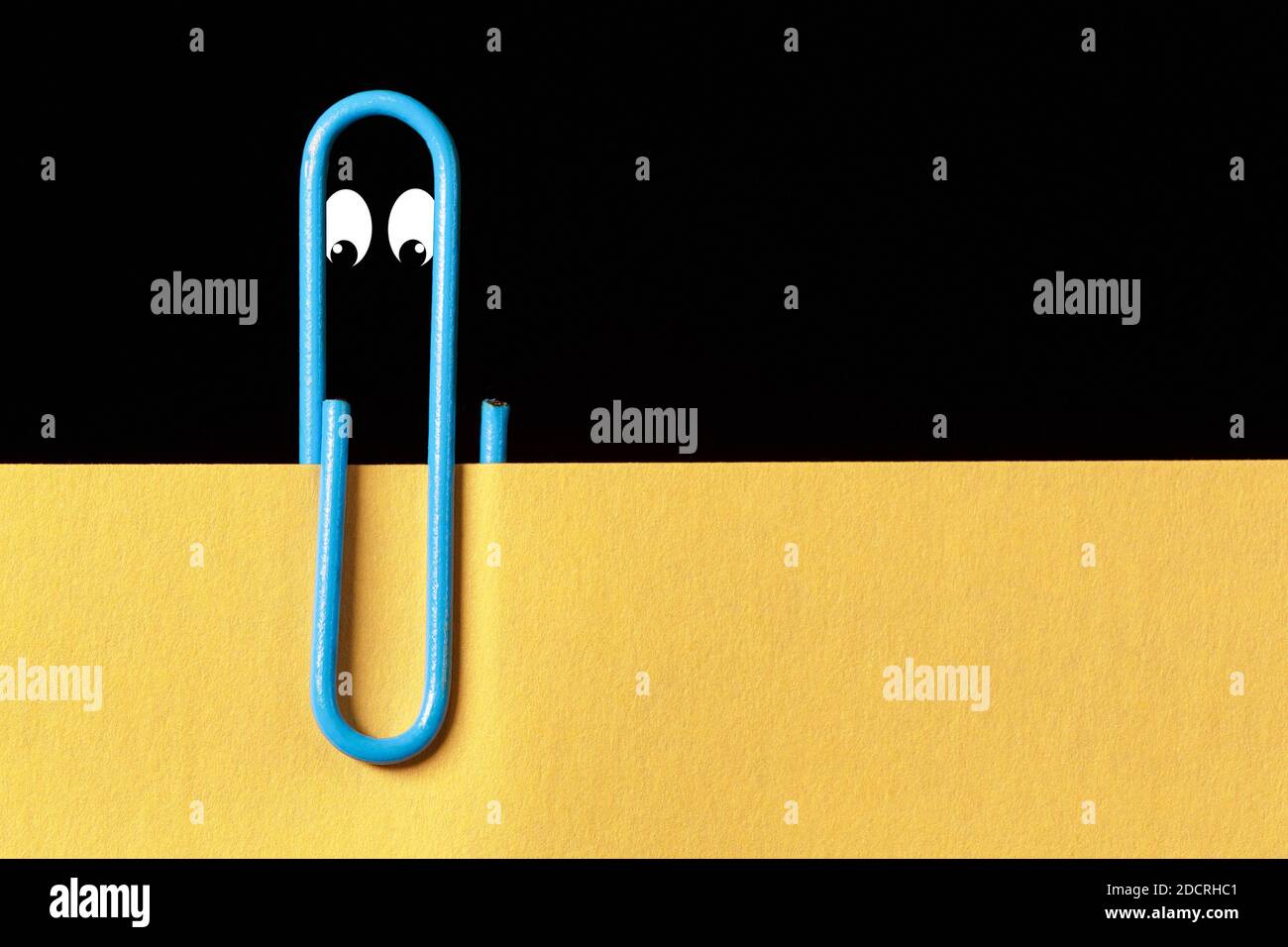 Paperclip with eyes peeking out from behind a sheet of paper Stock ...
