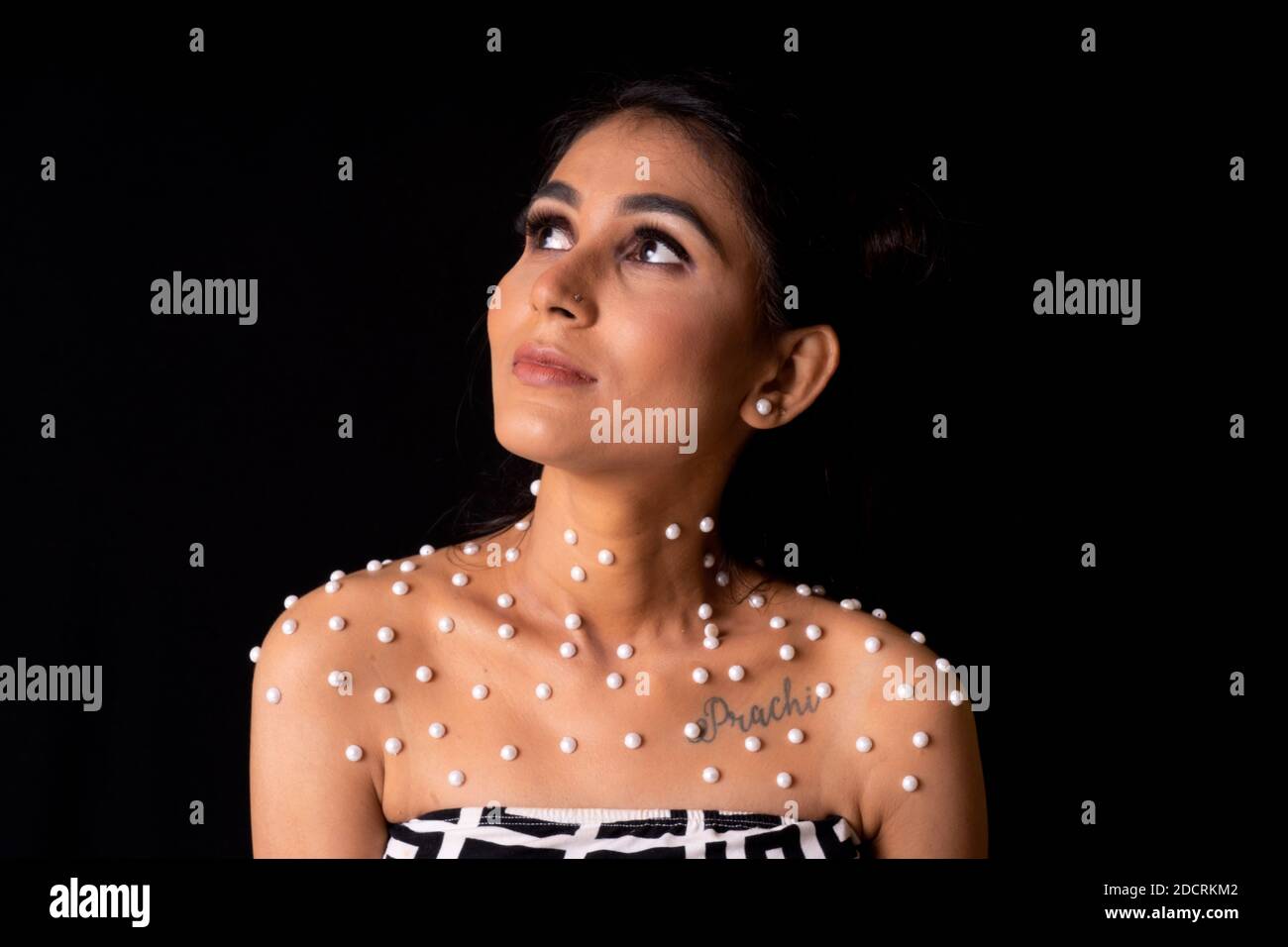 Indian female model looking up. Pensive and thinking. Black background ...