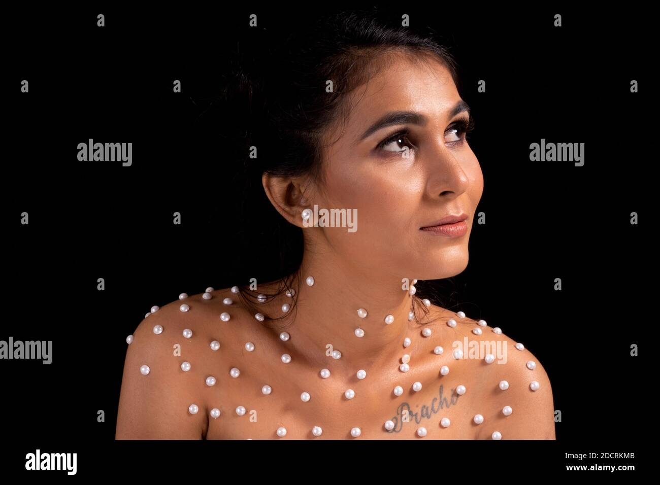 Indian female model looking up. Pensive and thinking. Black background ...