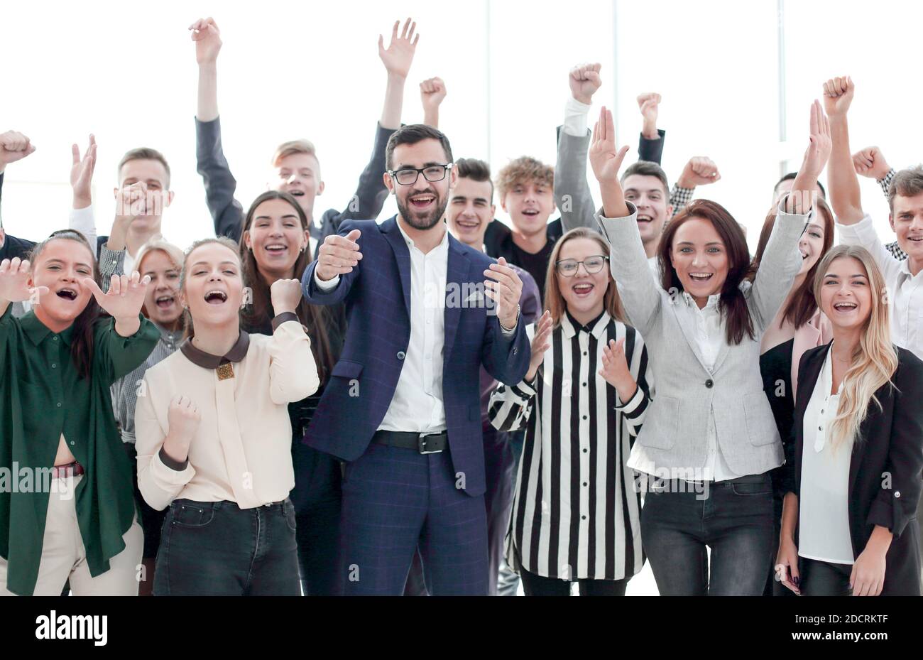happy group of young employees with hands up Stock Photo - Alamy