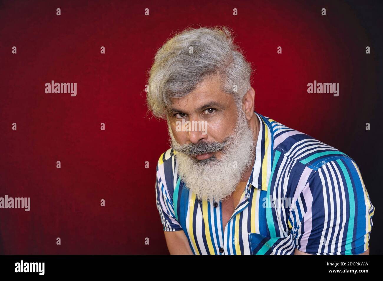 Man with long white beard, muscular body. Looking at camera. Red ...