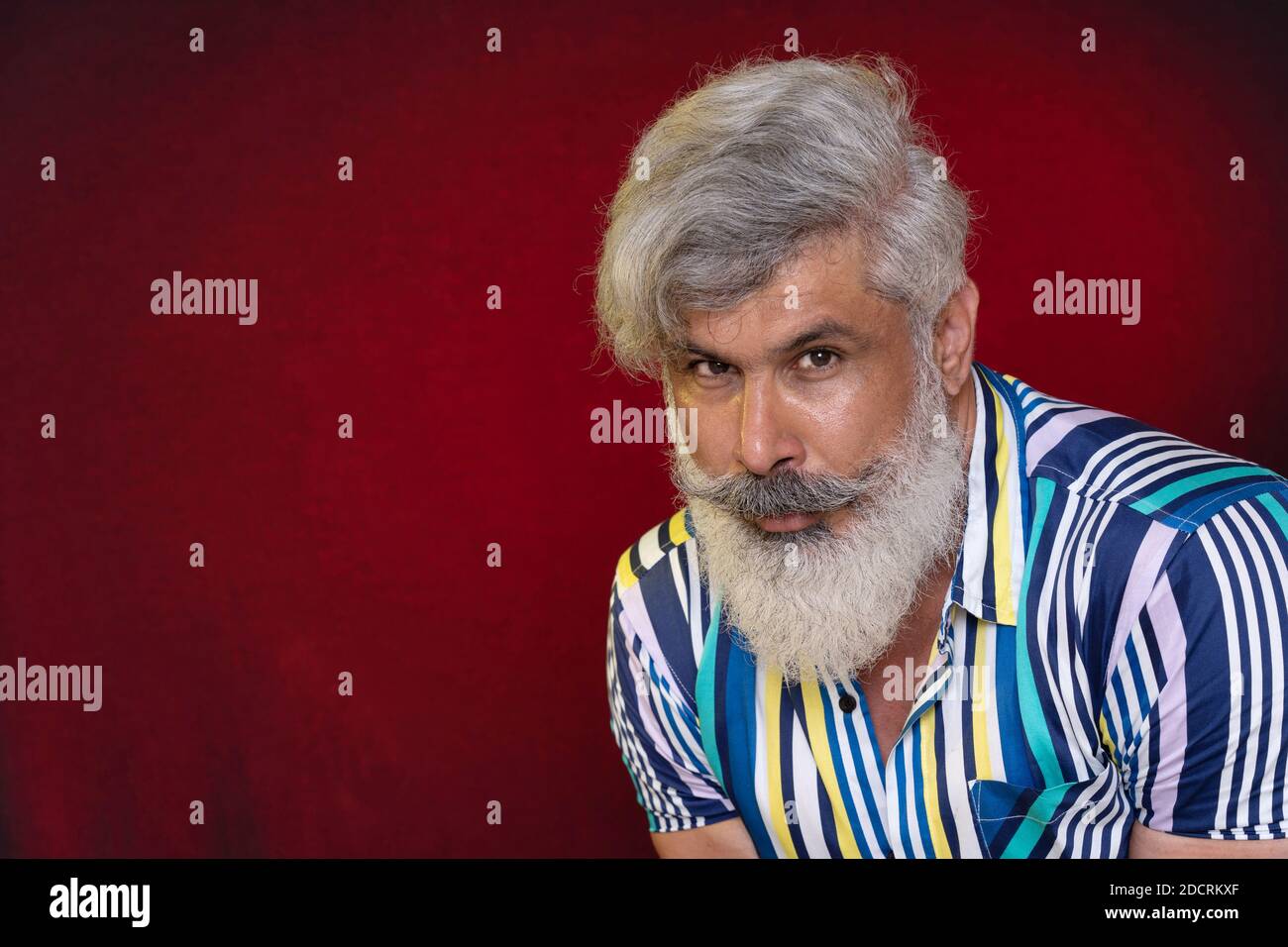 Man with long white beard, muscular body. Looking at camera. Red ...