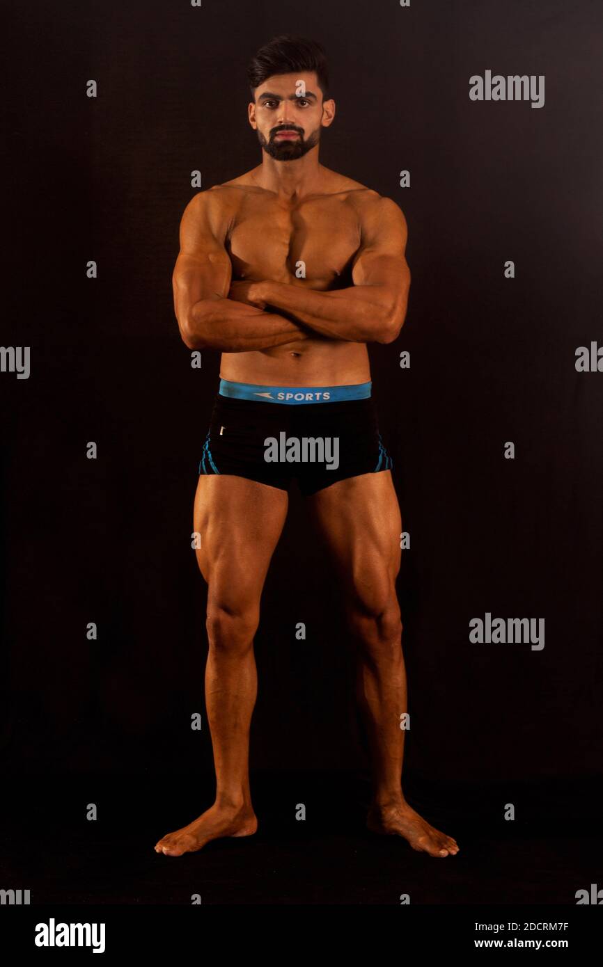 Muscular bodybuilder male in gym. Black background. Front profile ...