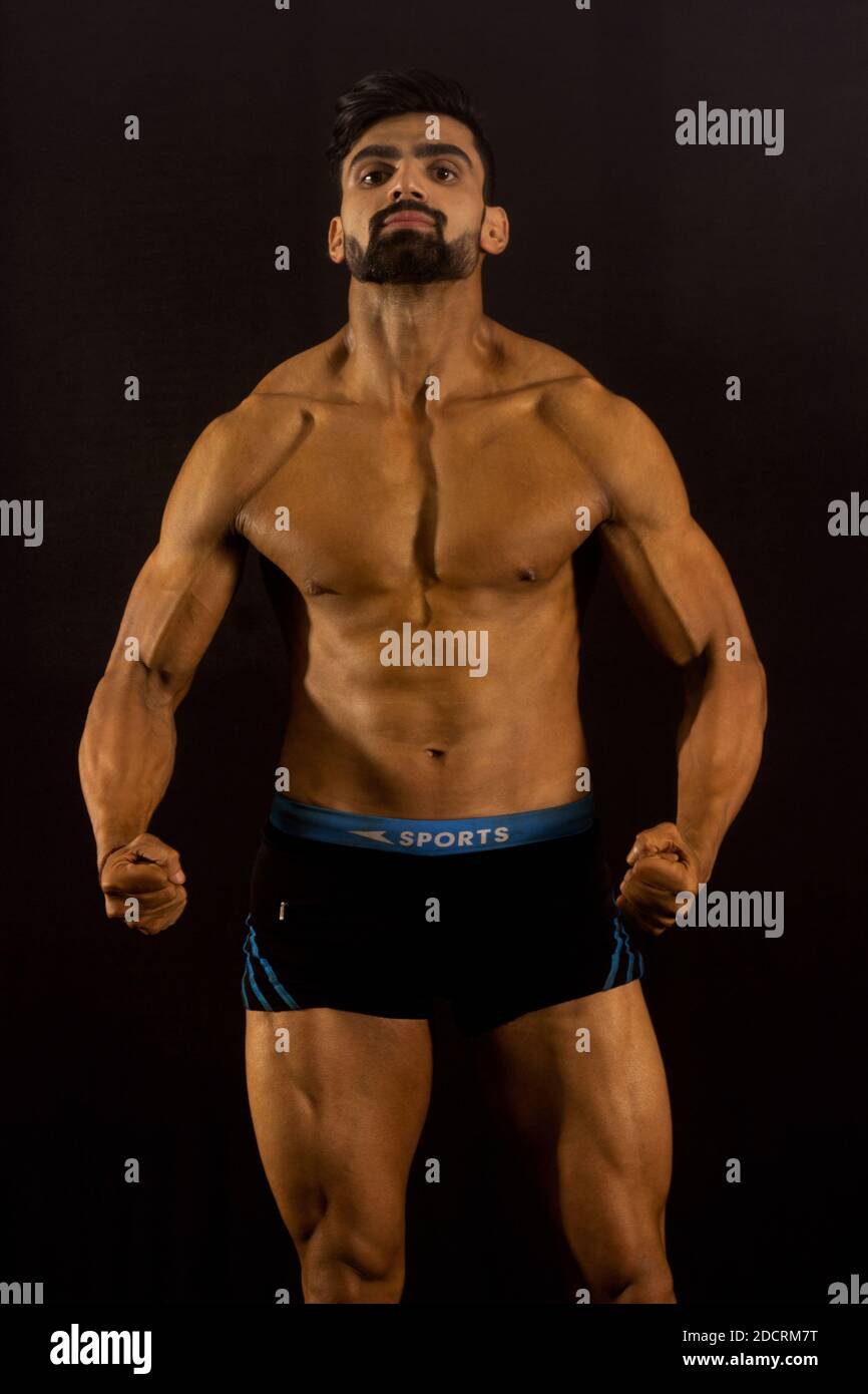 Muscular bodybuilder male in gym. Black background. Front profile ...
