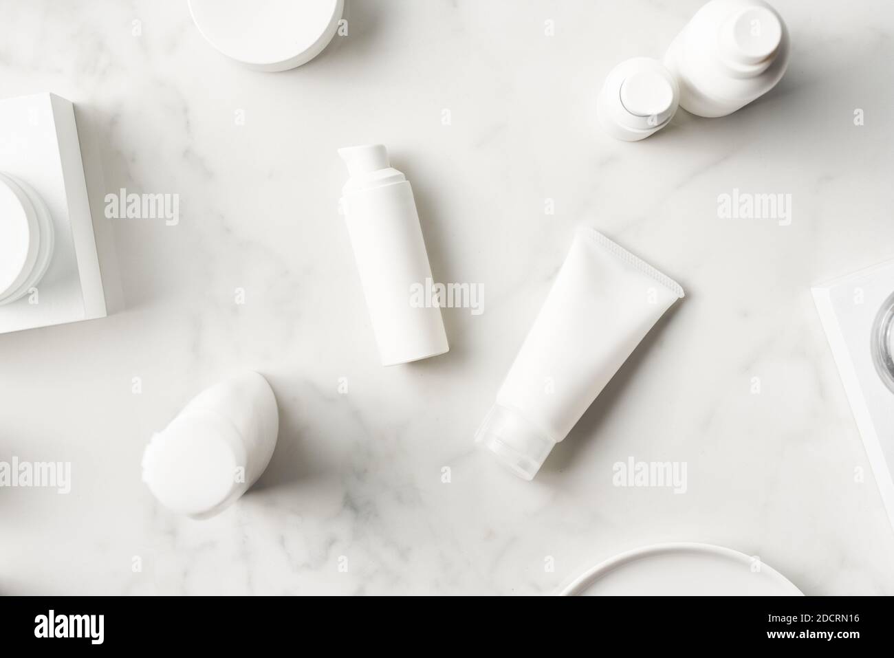 Top view of tubes with beauty products place on marble table in ...