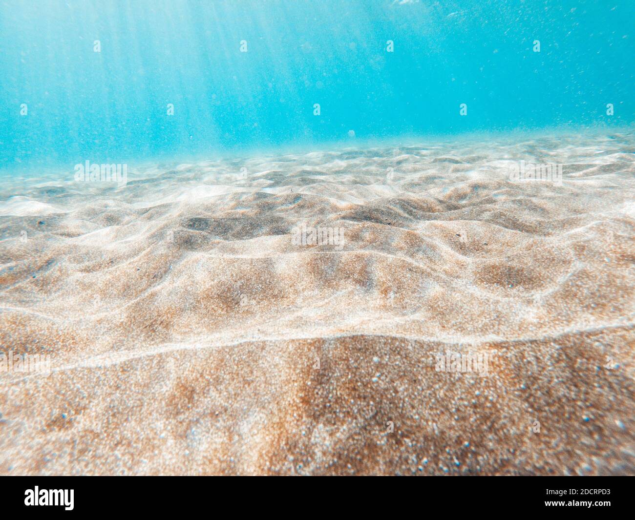 Underwater view at the beach with sand and blue transparent clean water ...