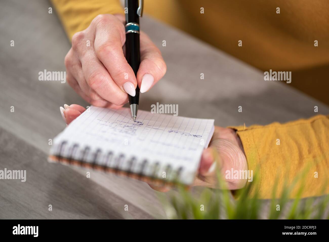 Female hands with pen writing on notepad Stock Photo - Alamy
