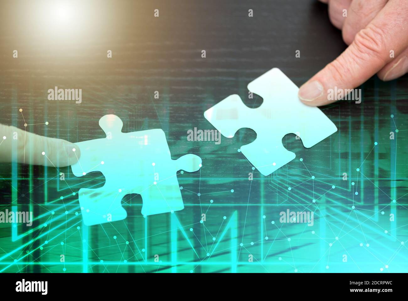 Hands joining two puzzle pieces, teamwork concept; multiple exposure ...