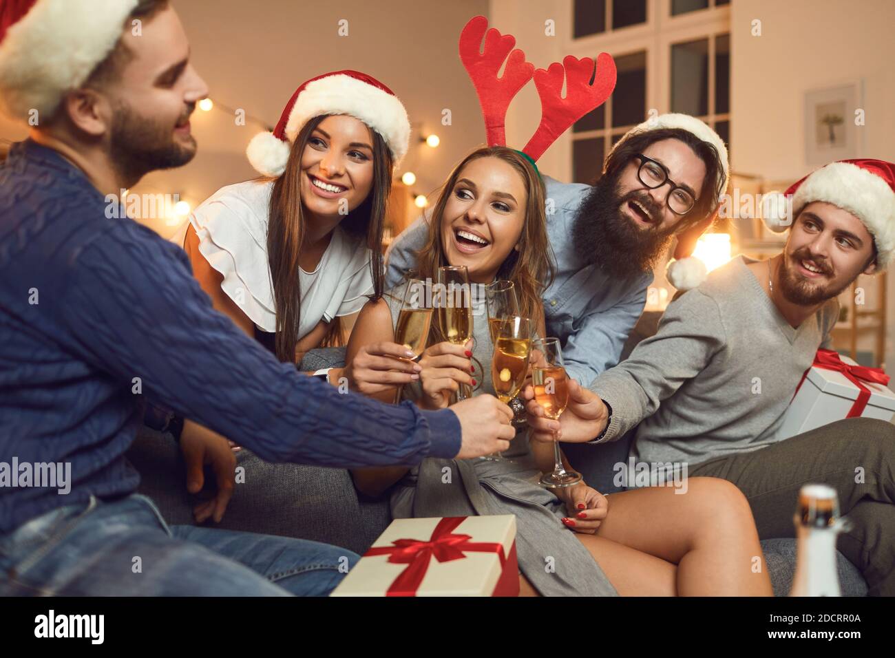 Group of cheerful friends are clinking glasses of champagne and say ...