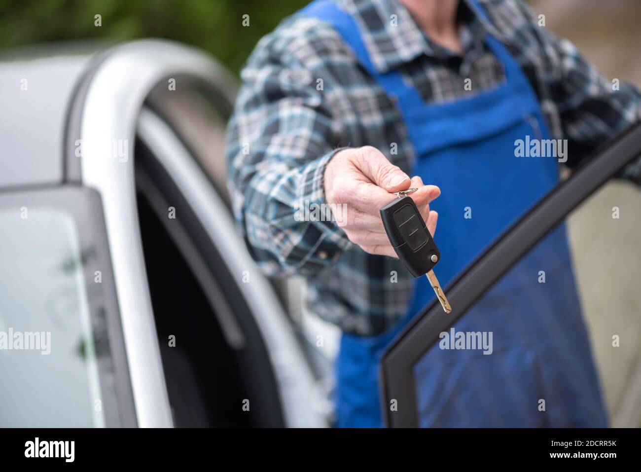 Car mechanic delivering car keys after car engine checking Stock Photo ...