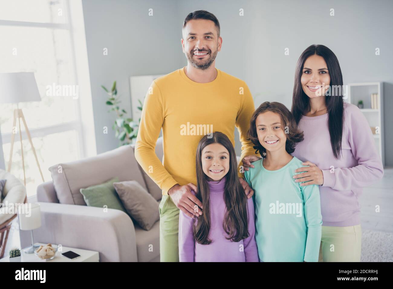 Photo of big family four people gathering two little kids hands ...