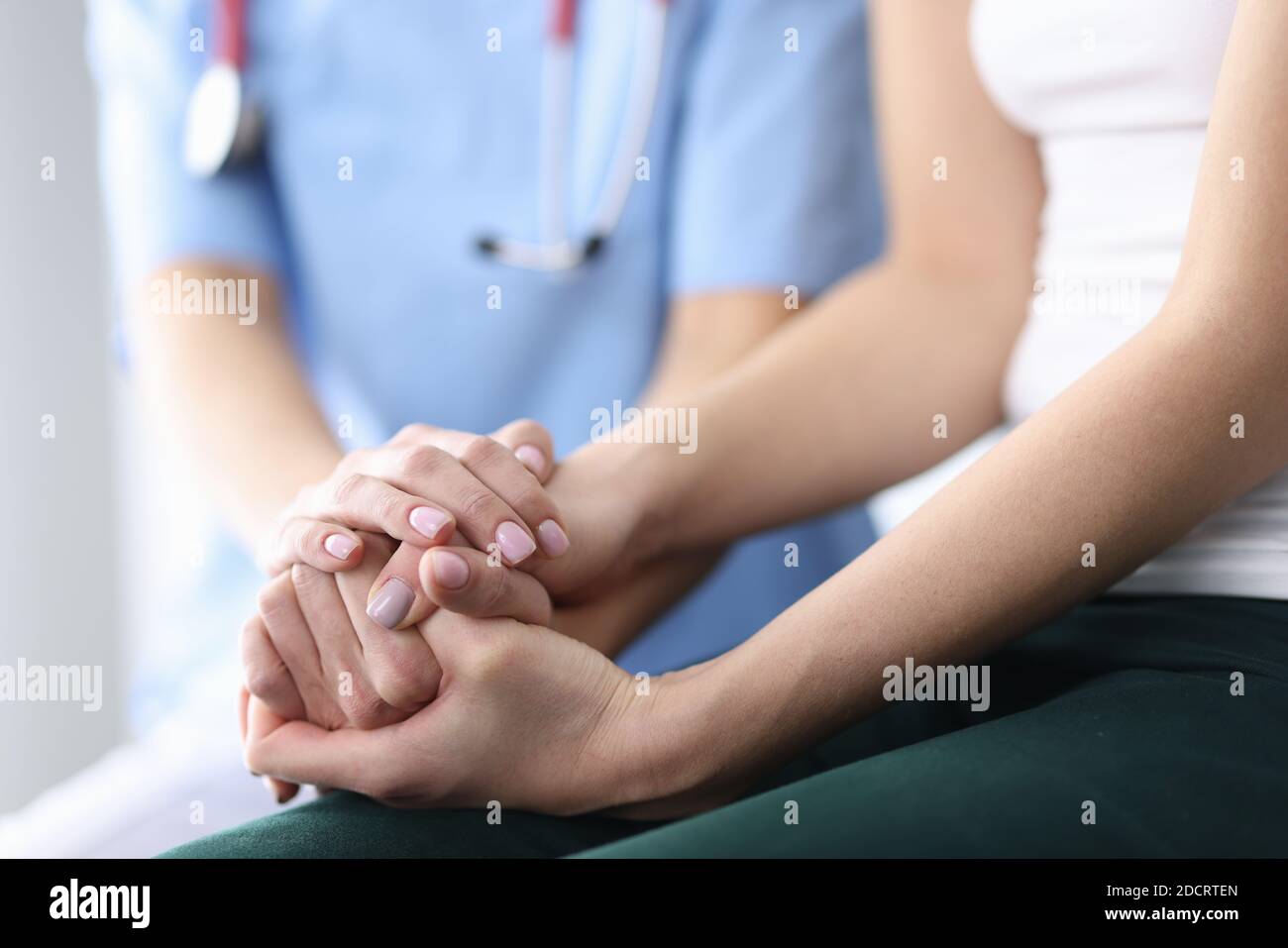 Patient's and doctor's hands are folded together Stock Photo - Alamy